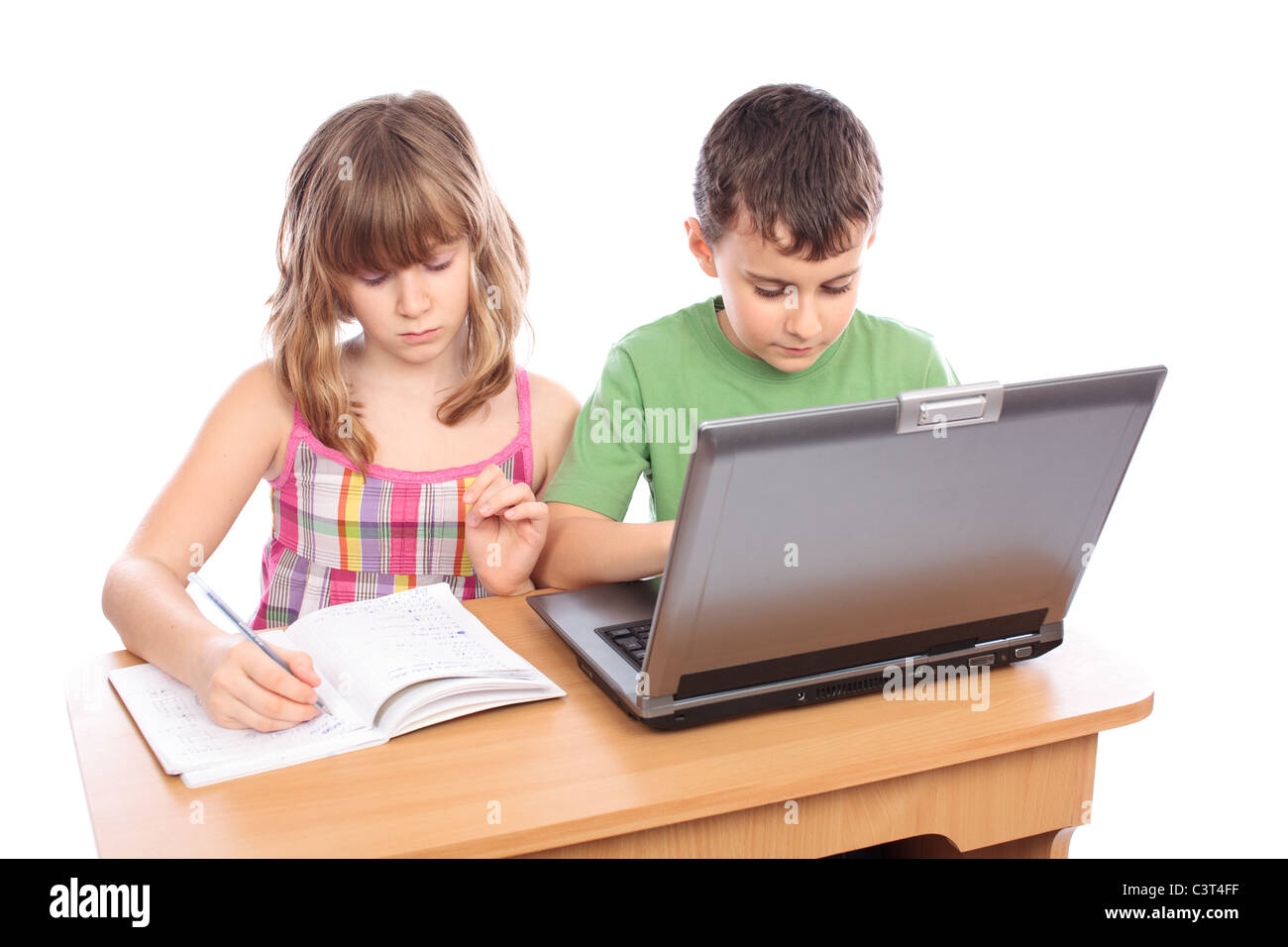 Two school children doing homework together with computer, isolated on ...