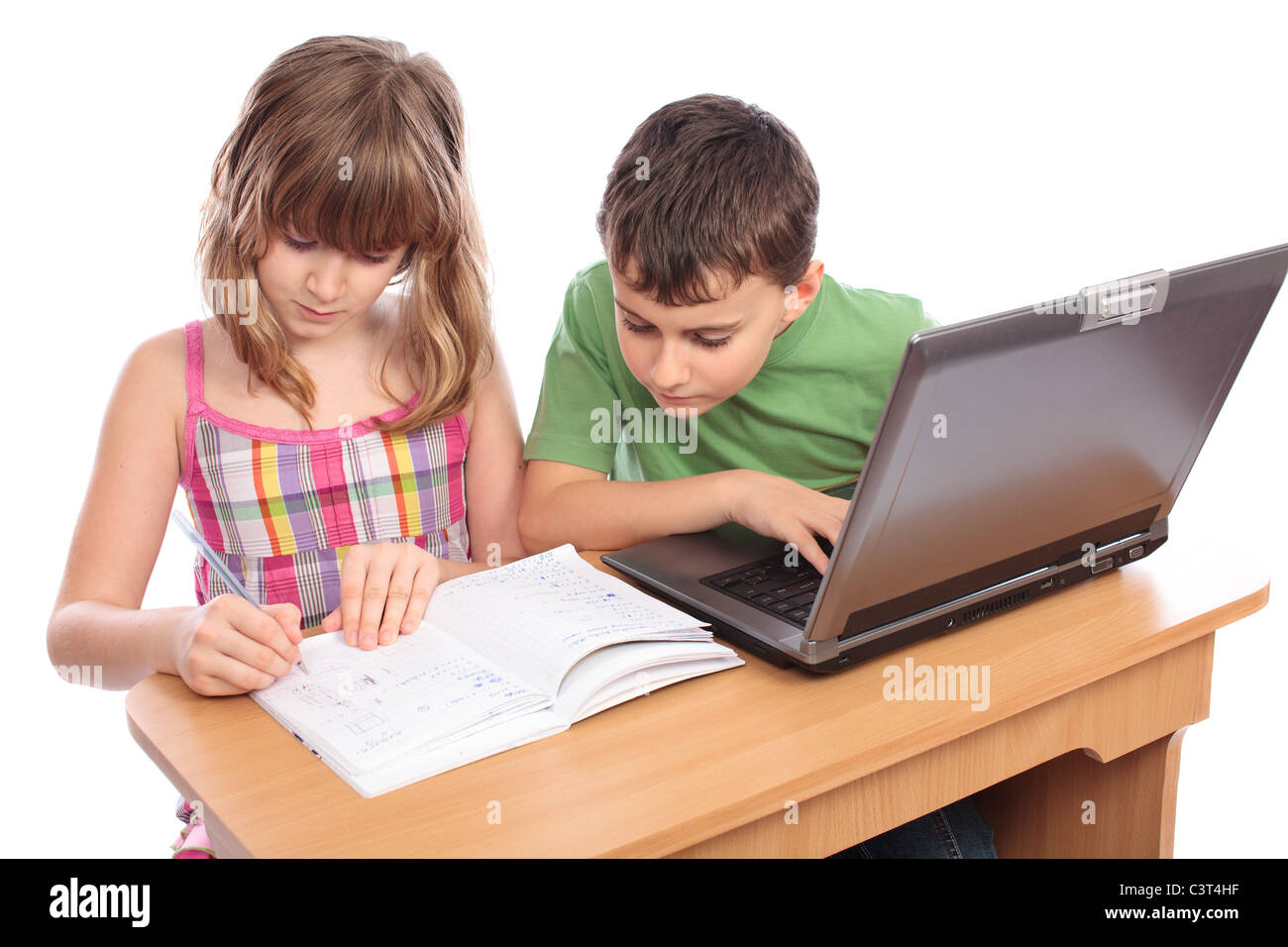 Two school children doing homework together with computer, isolated on ...