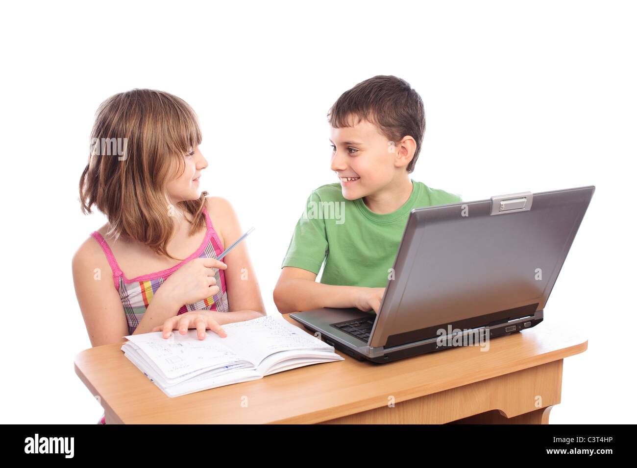Two school children doing homework together with computer, isolated on ...