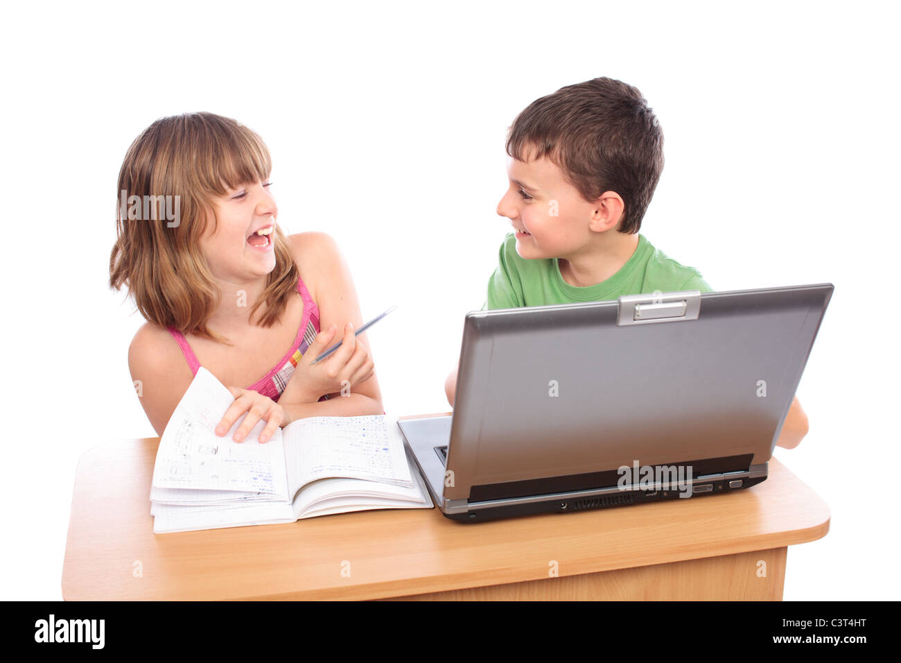 Two school children doing homework together with computer, isolated on ...
