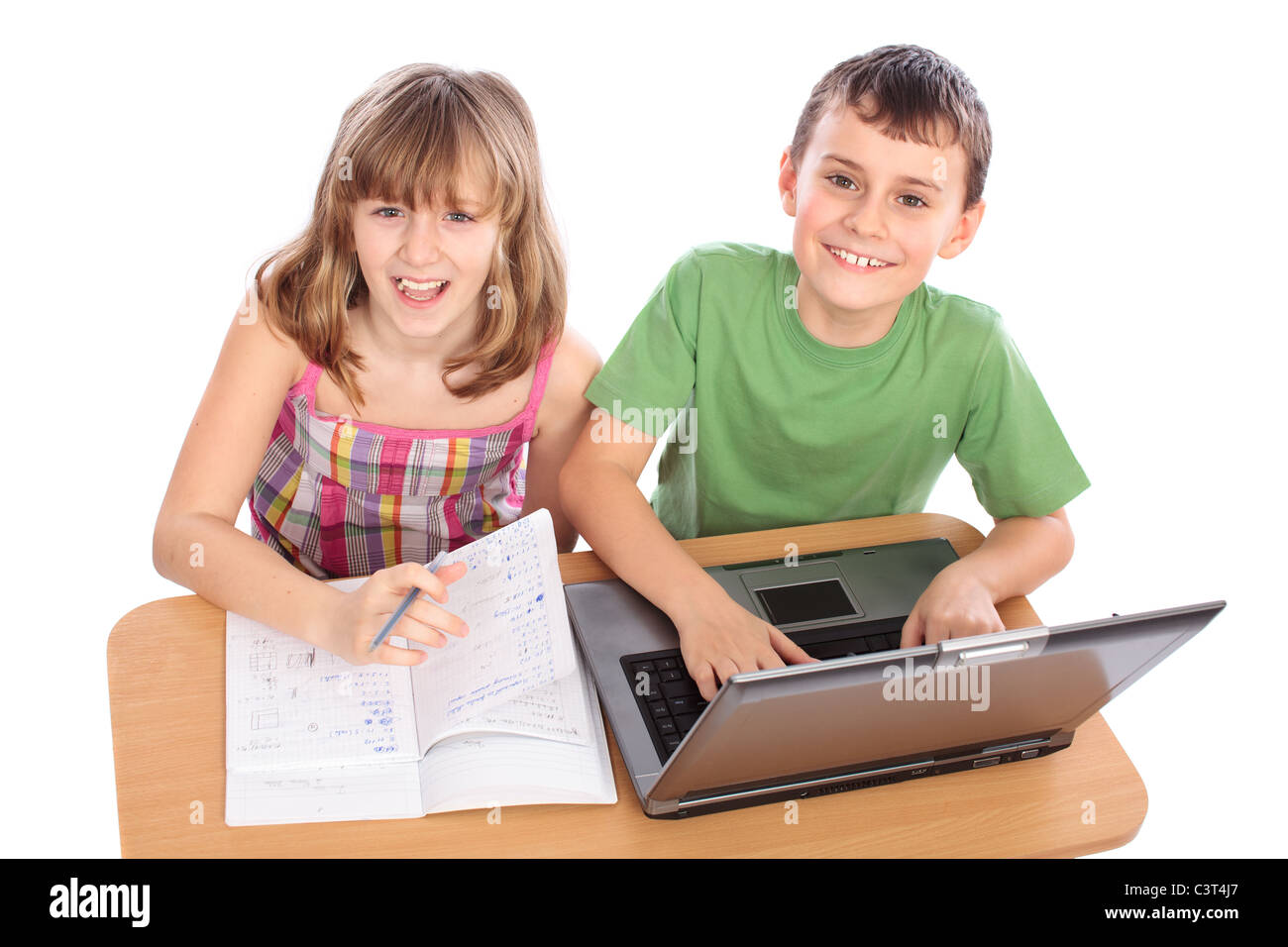 Two school children doing homework together with computer, isolated on ...