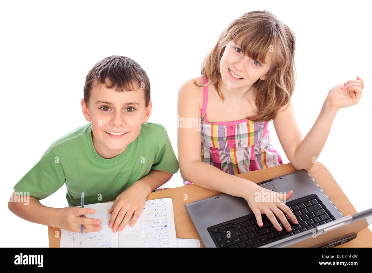 Two school children doing homework together with computer, isolated on ...
