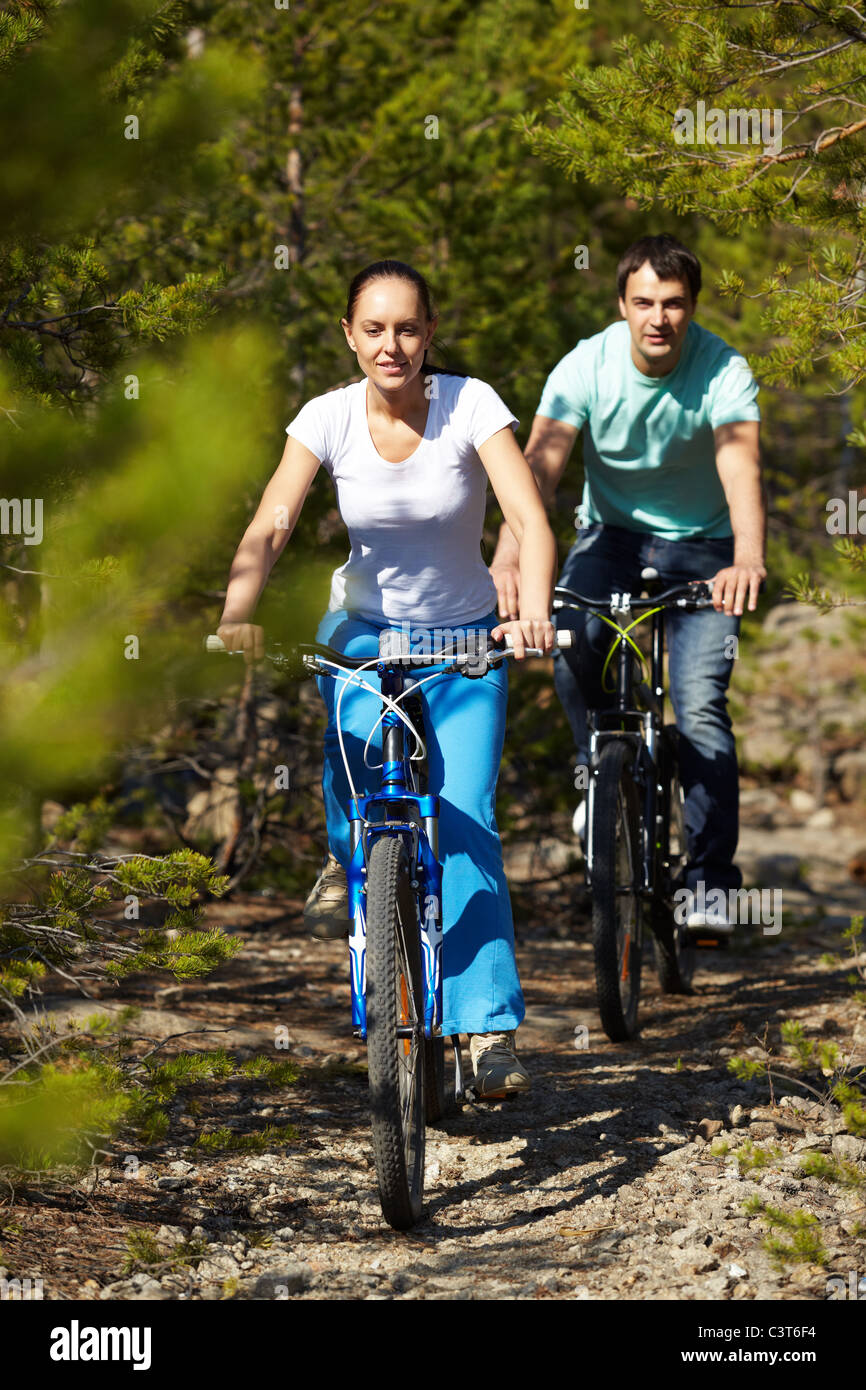 A young people riding bicycles in wood Stock Photo - Alamy