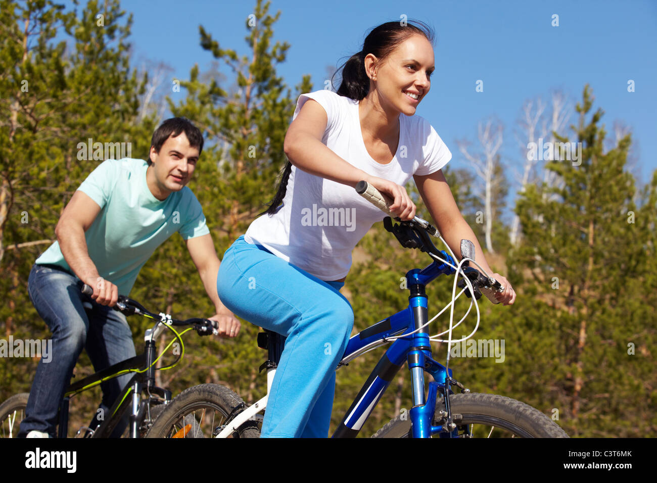 A young couple racing on bicycles Stock Photo - Alamy