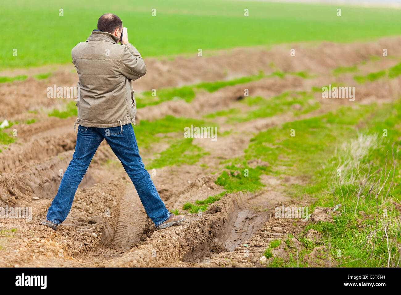 Professional photographer in the grass field shooting landscapes Stock ...