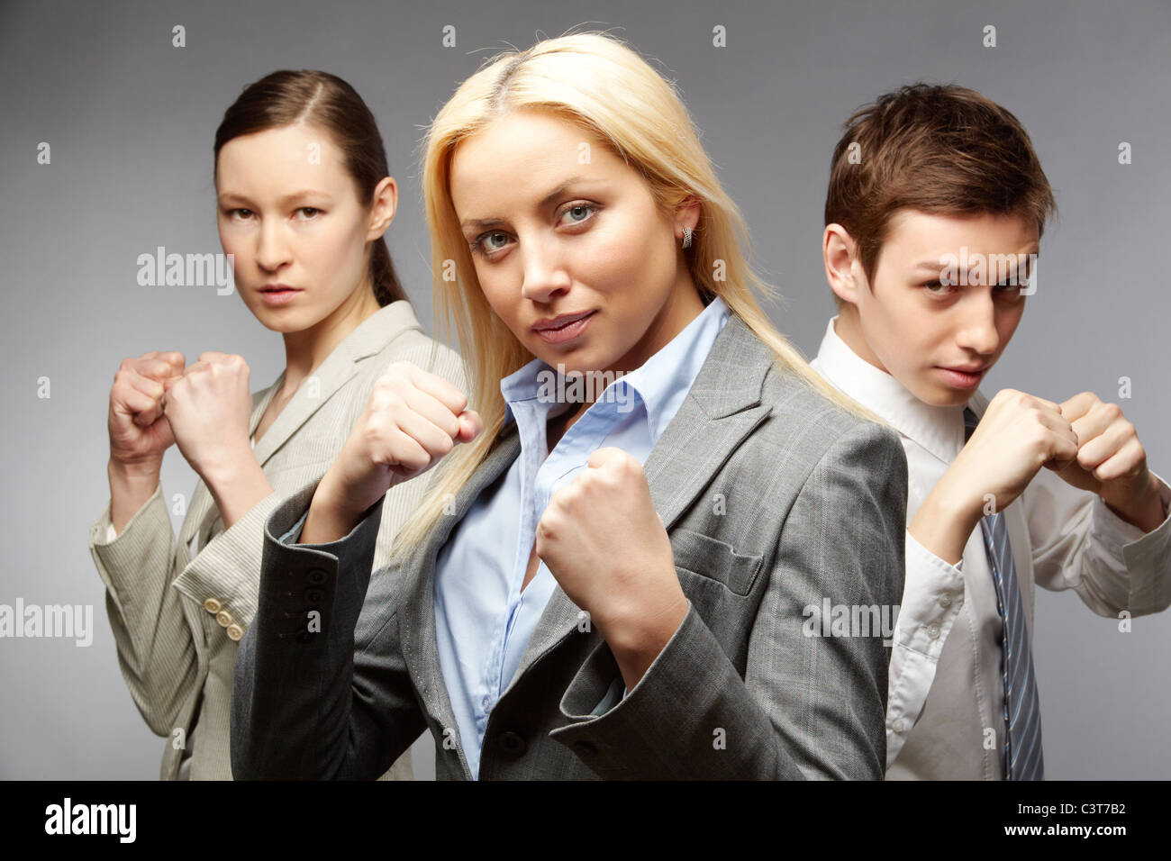 Three determined businesspeople in defense pose Stock Photo - Alamy