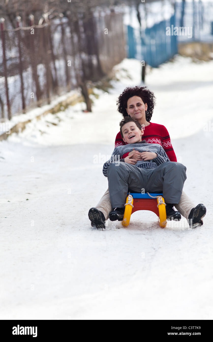 Mother and son on a sledge at speed, having fun Stock Photo - Alamy