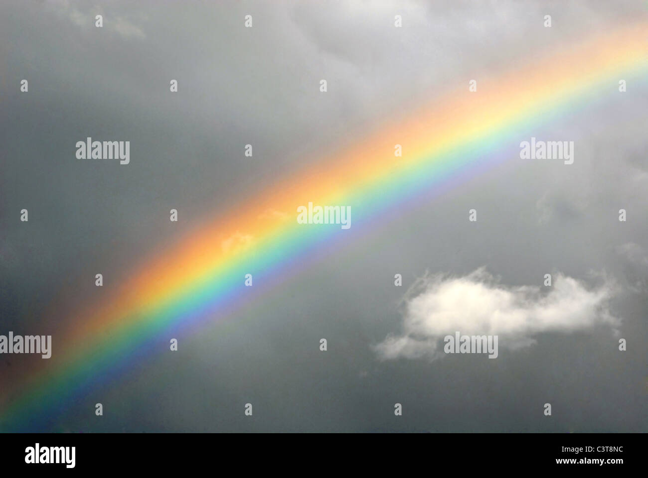 Rainbow on grey cloudy sky Stock Photo - Alamy