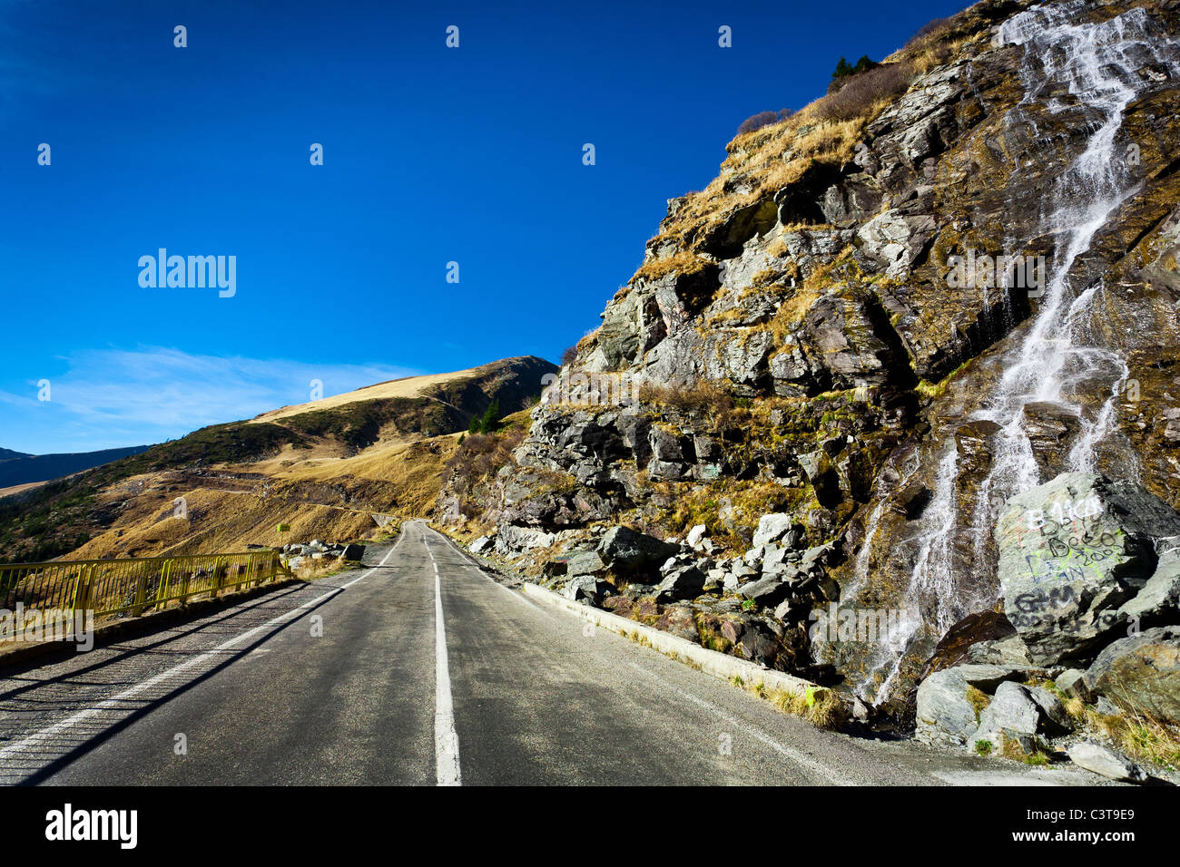 Landscape with road and mountains, a small waterfall on the right Stock ...