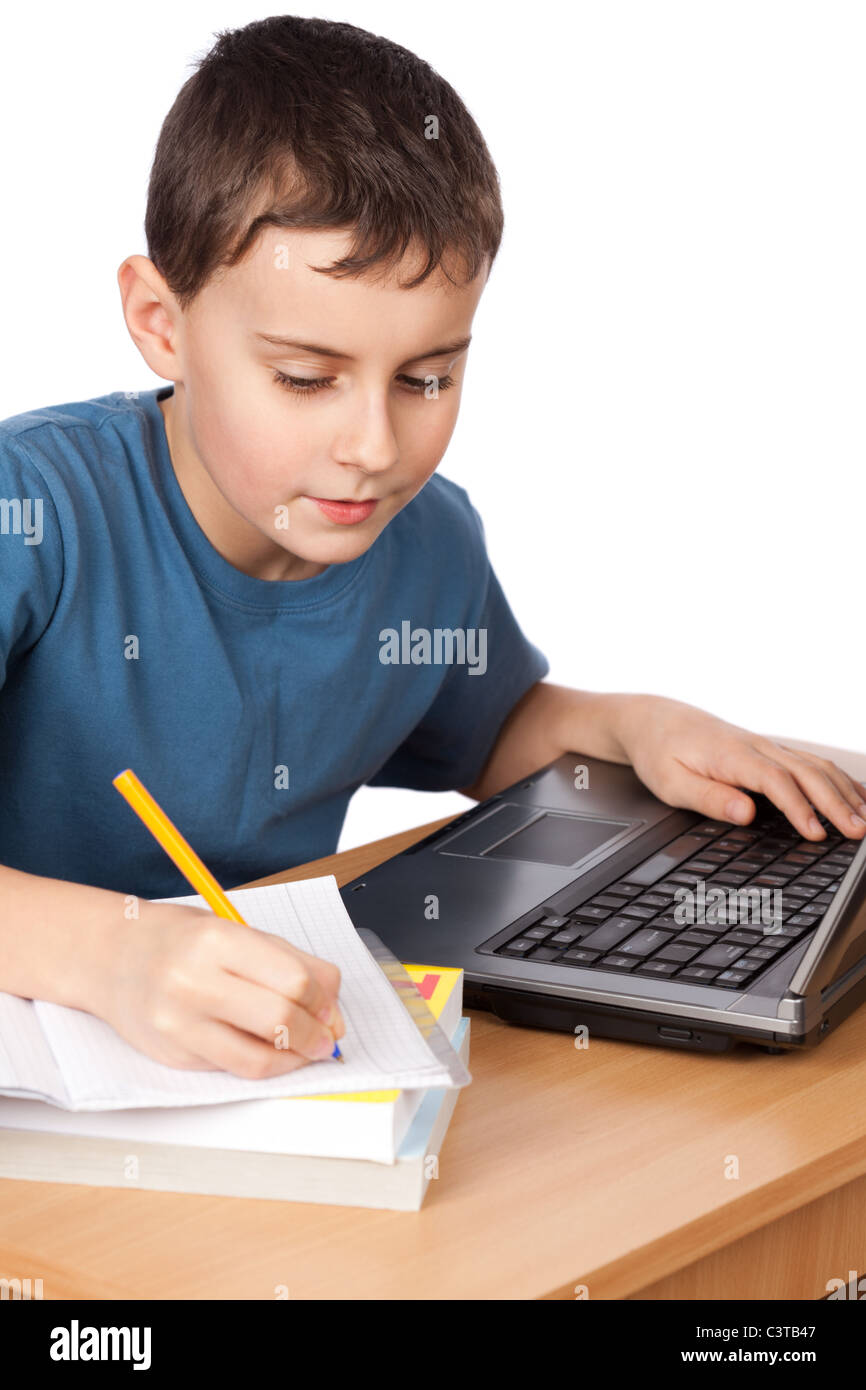 Portrait of a boy doing his homework at the laptop, isolated on white ...
