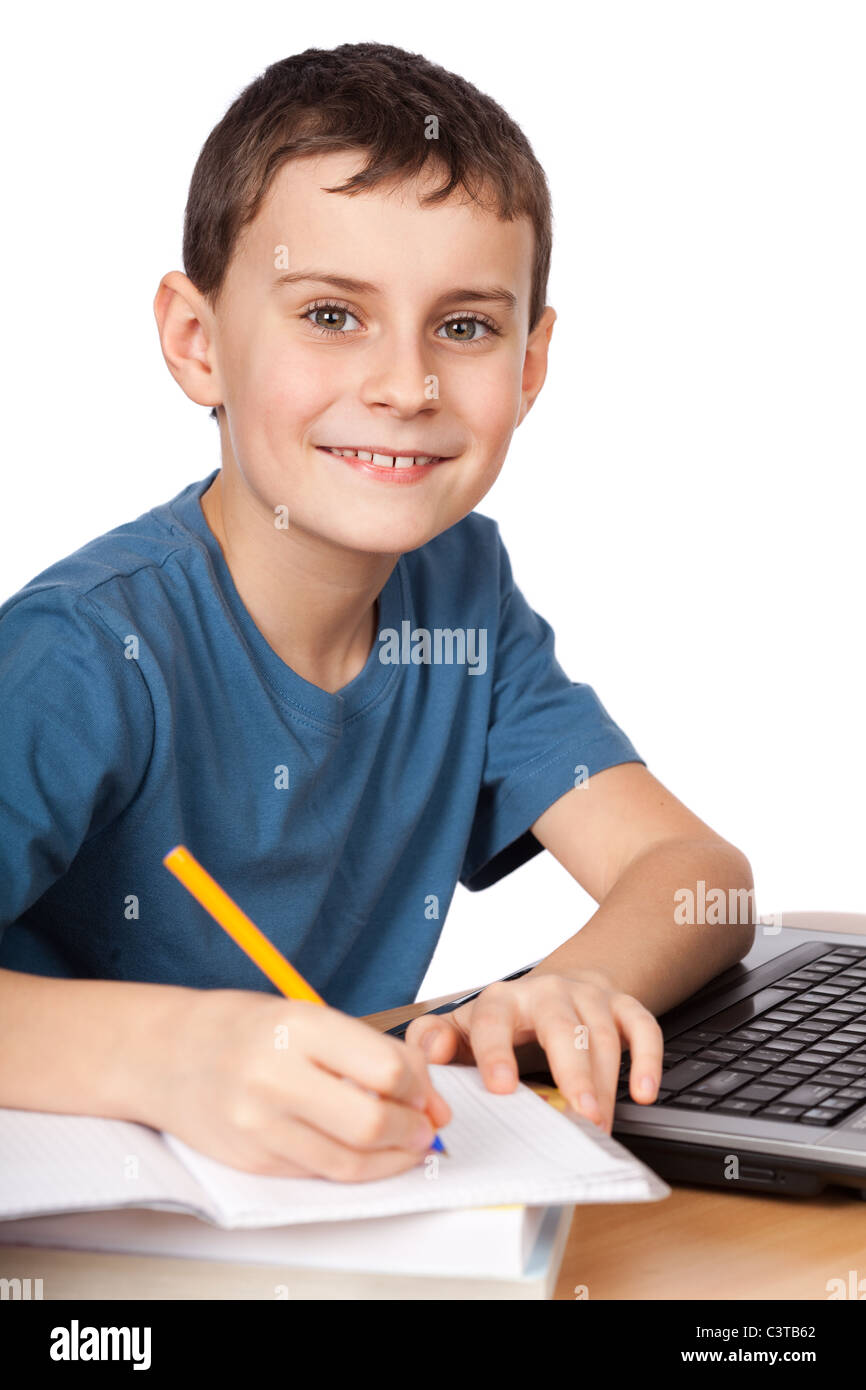 Portrait of a boy doing his homework at the laptop, isolated on white ...