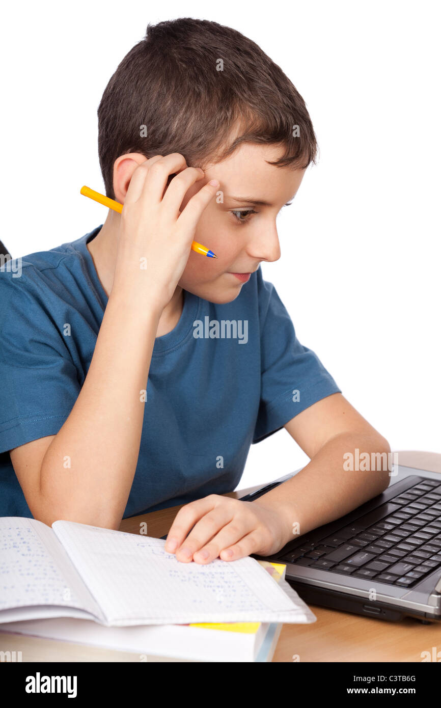 Portrait of a boy doing his homework at the laptop, isolated on white ...