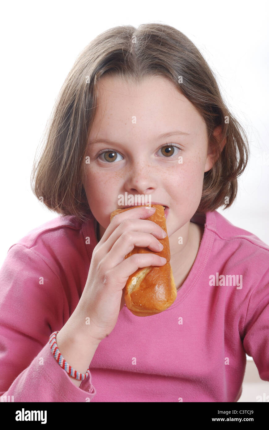 A young girl eating a bun Stock Photo - Alamy