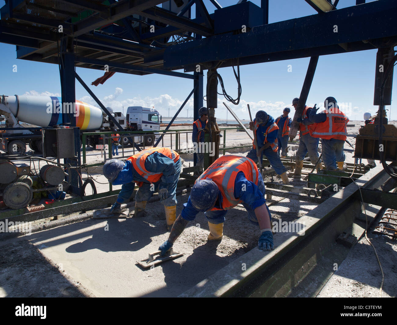 Workers pouring concrete making a new quay of the deep sea port ...