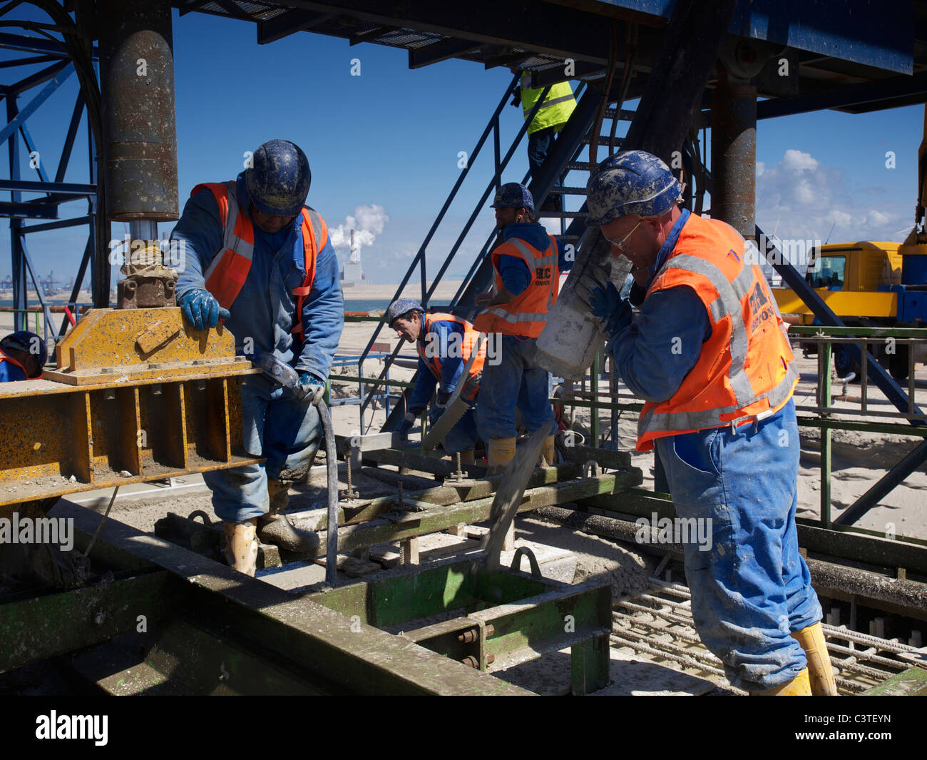 Workers pouring concrete making a new quay of the deep sea port ...