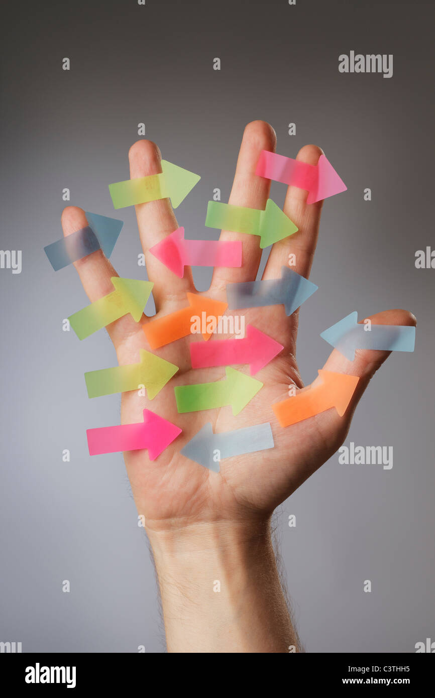 Hand with adhesive arrows at different directions Stock Photo - Alamy