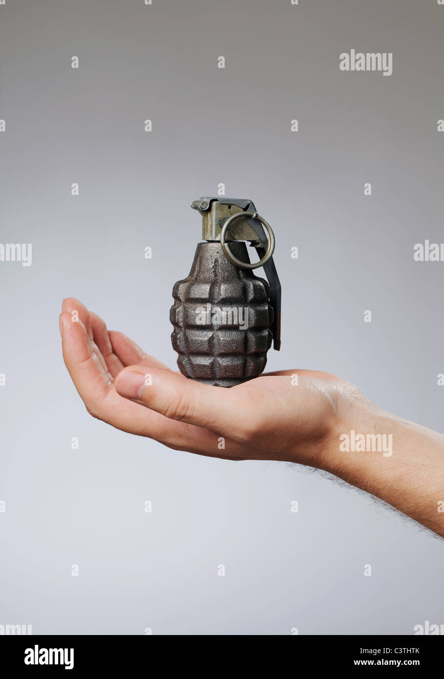 Man holding a hand grenade in his hand Stock Photo - Alamy