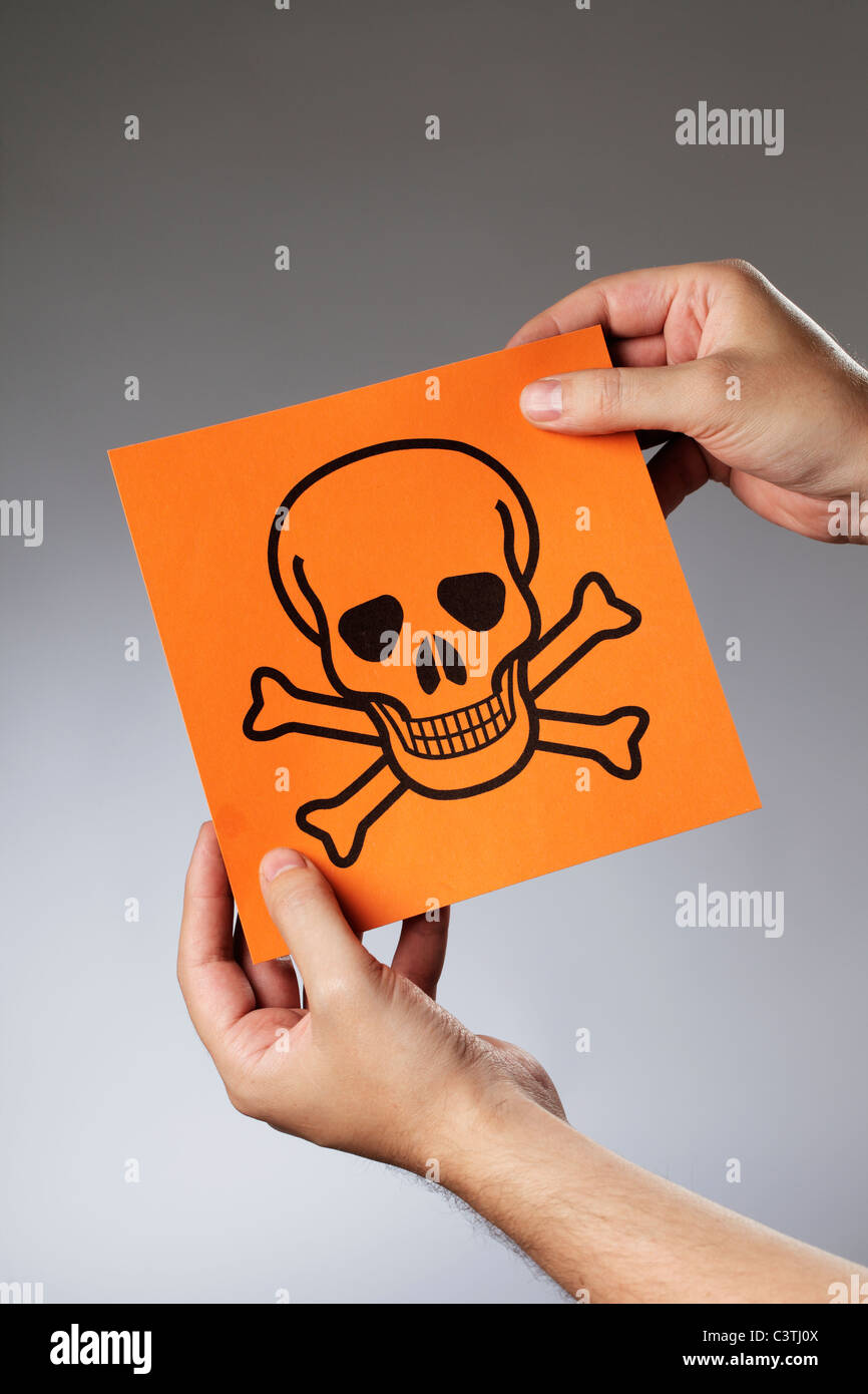 Man holding the symbol for poison in his hands Stock Photo - Alamy