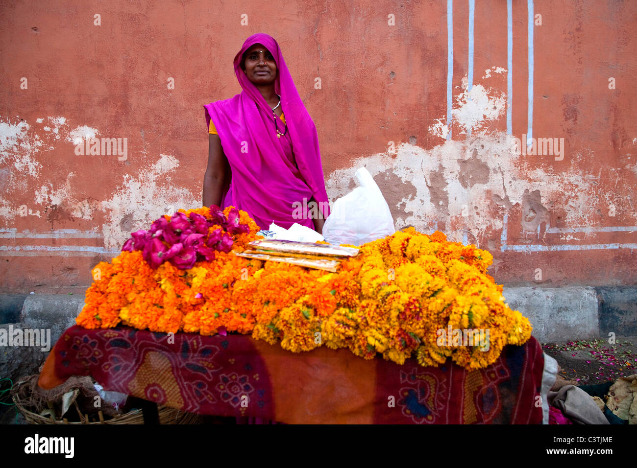 Indian woman with sari selling flowers at the market on the street ...