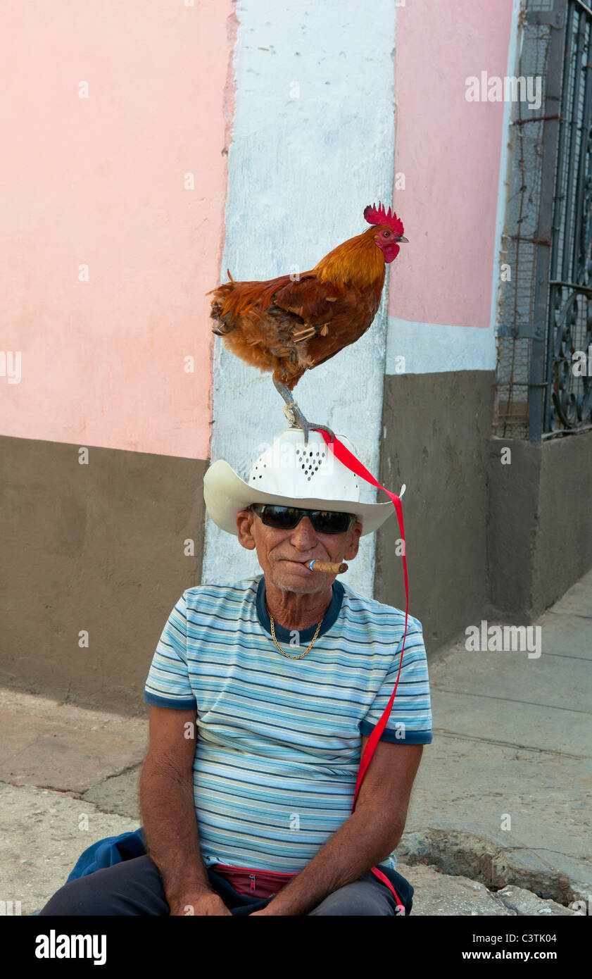 Old man with rooster on head in old Colonial village of Trinidad Cuba ...