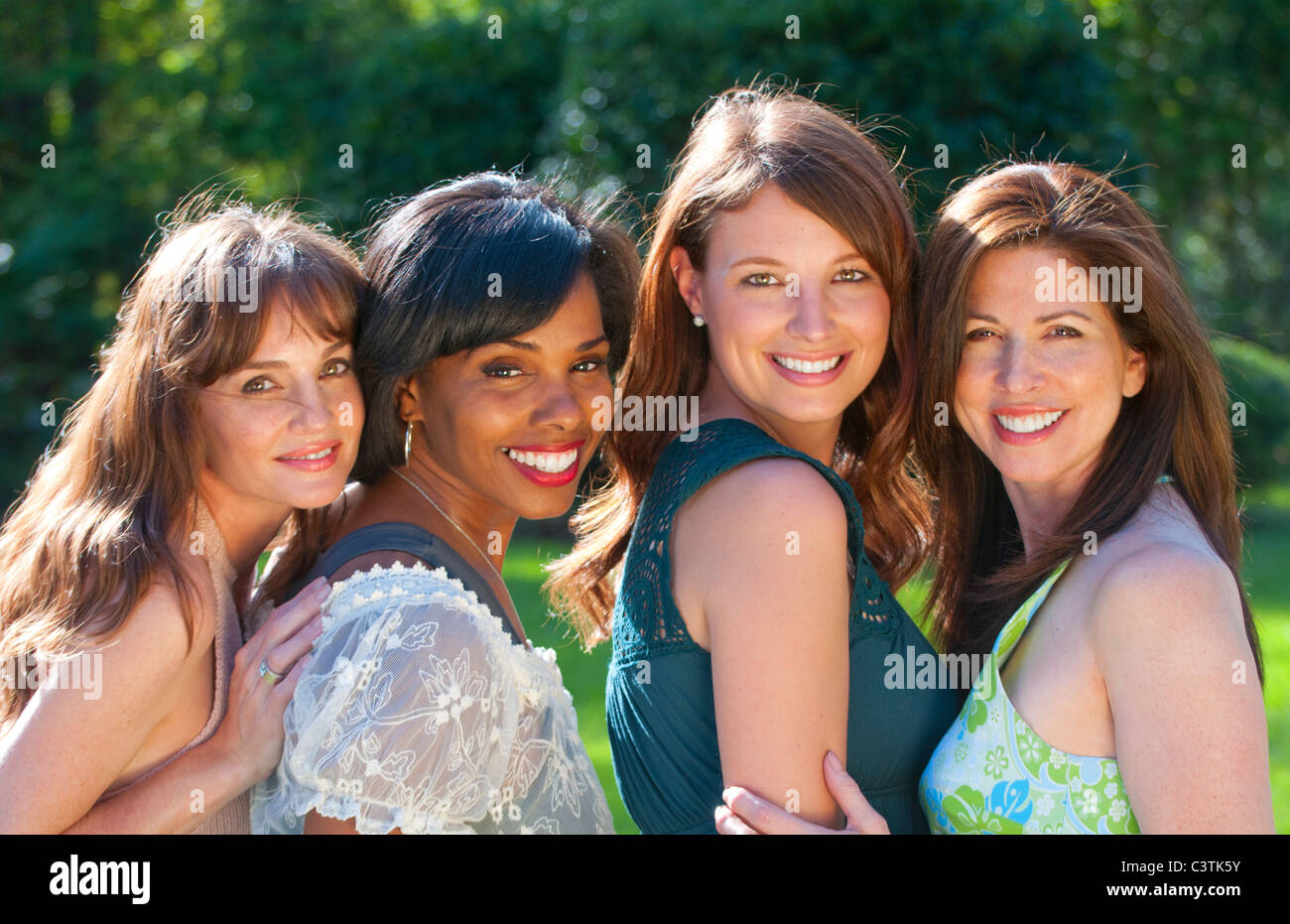 Girlfriends aged 20s and 30s having fun in sunshine at home in yard ...