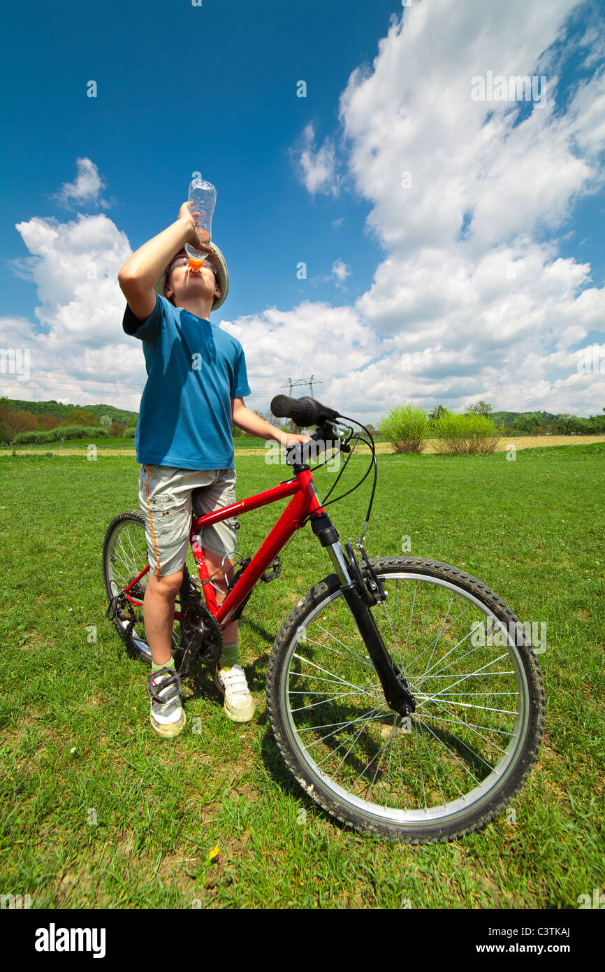 Boy on a bicycle stopped to have a break and drink water Stock Photo ...