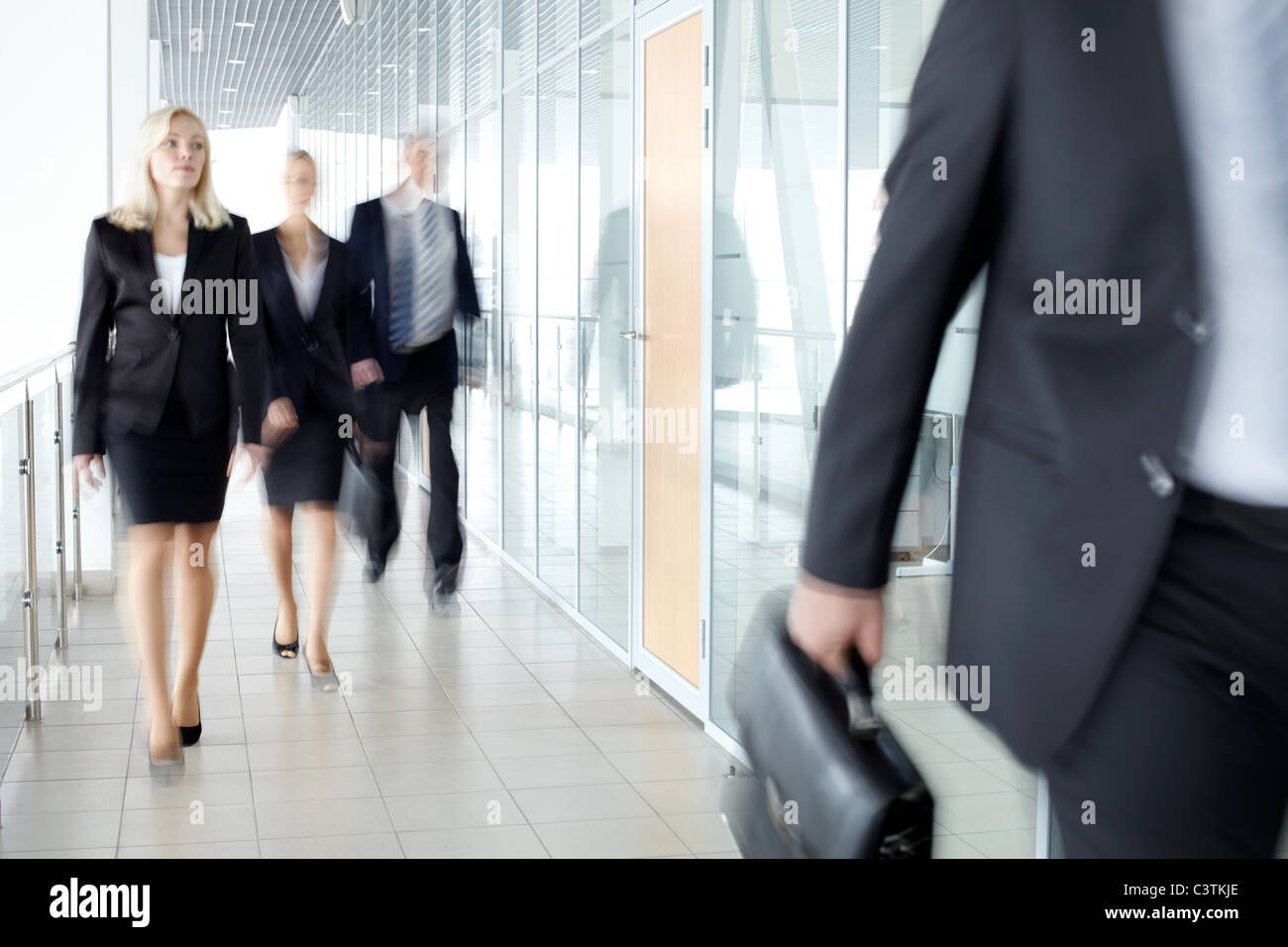 Business people walking along the office corridor Stock Photo - Alamy