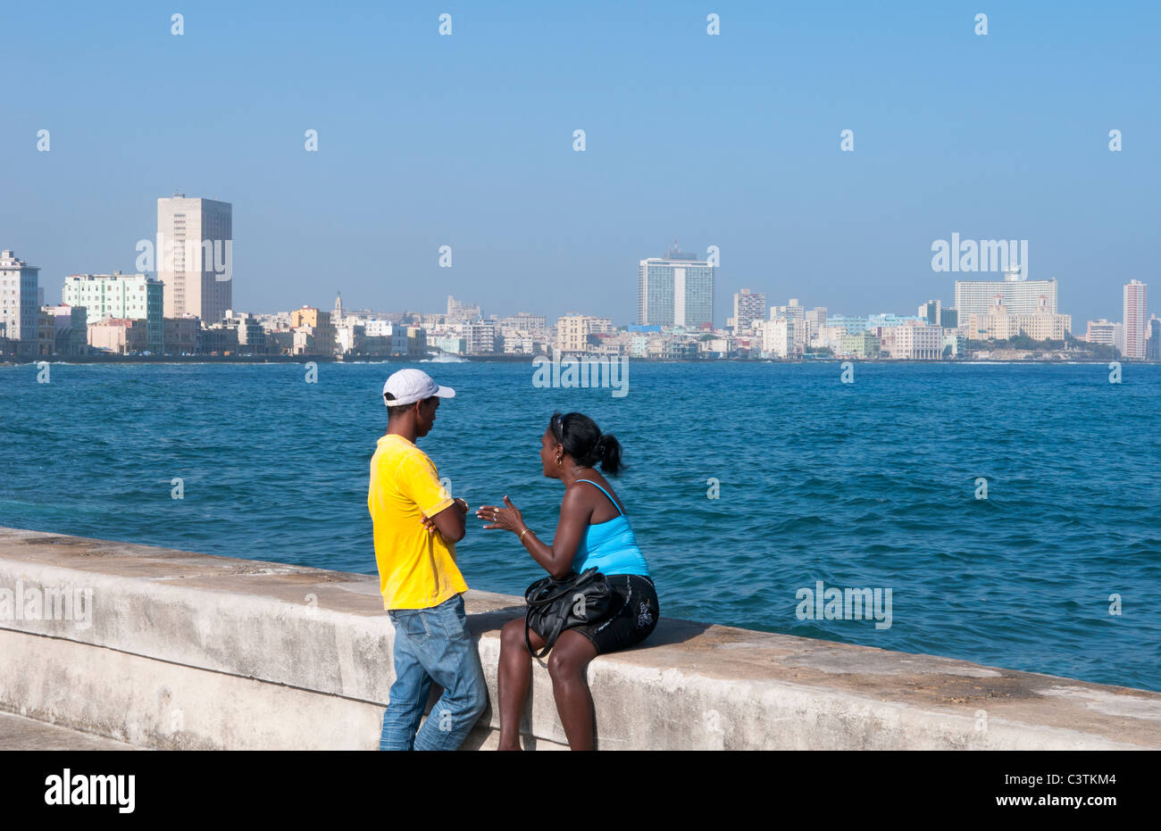 Couple talking at famous malecon on ocean shore water in Havana Cuba Stock Photo - Alamy