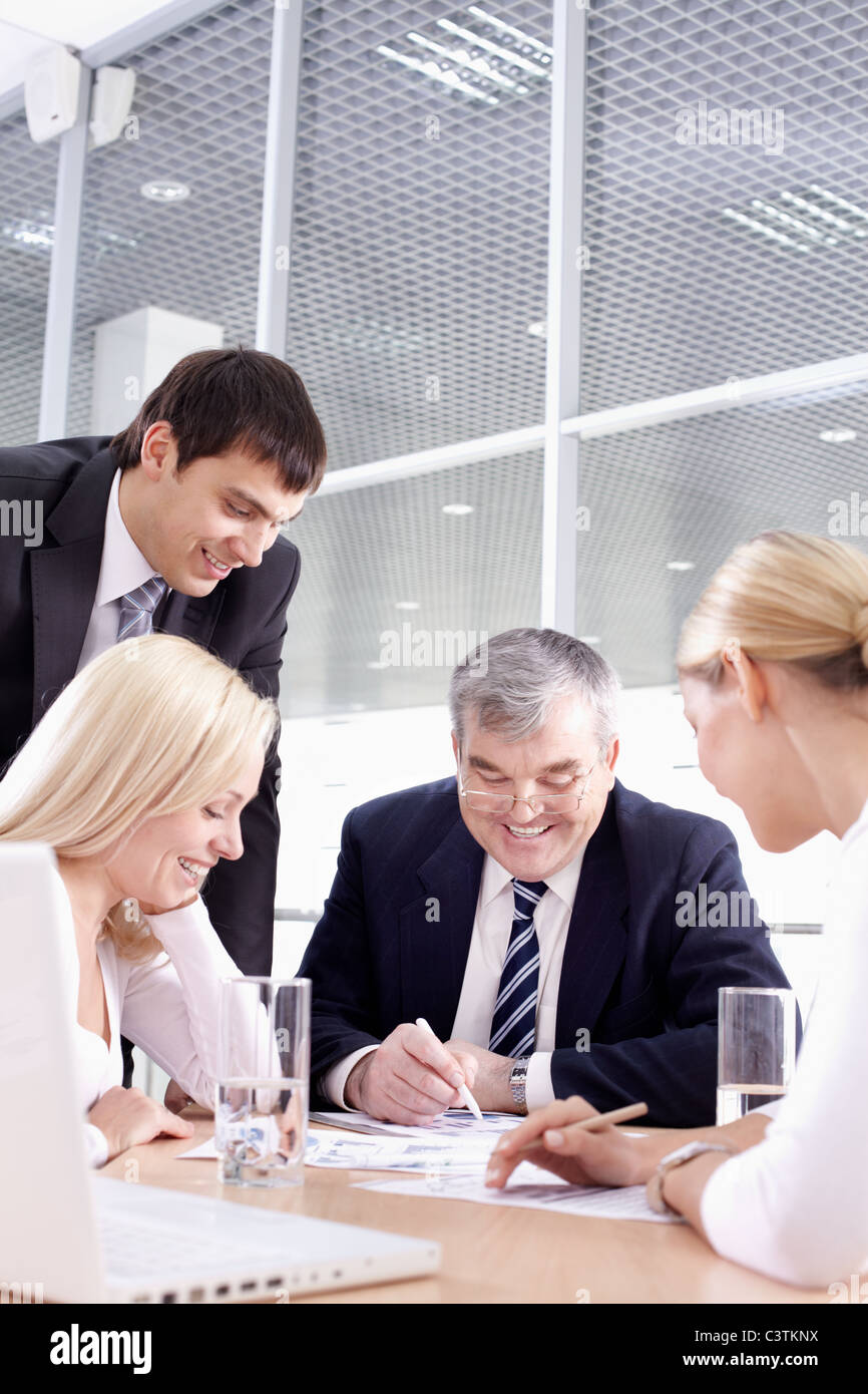 Business team of four people sitting and working together Stock Photo ...