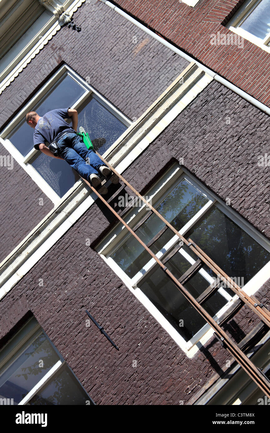 A man cleaning the windows of the building in the historic district of ...