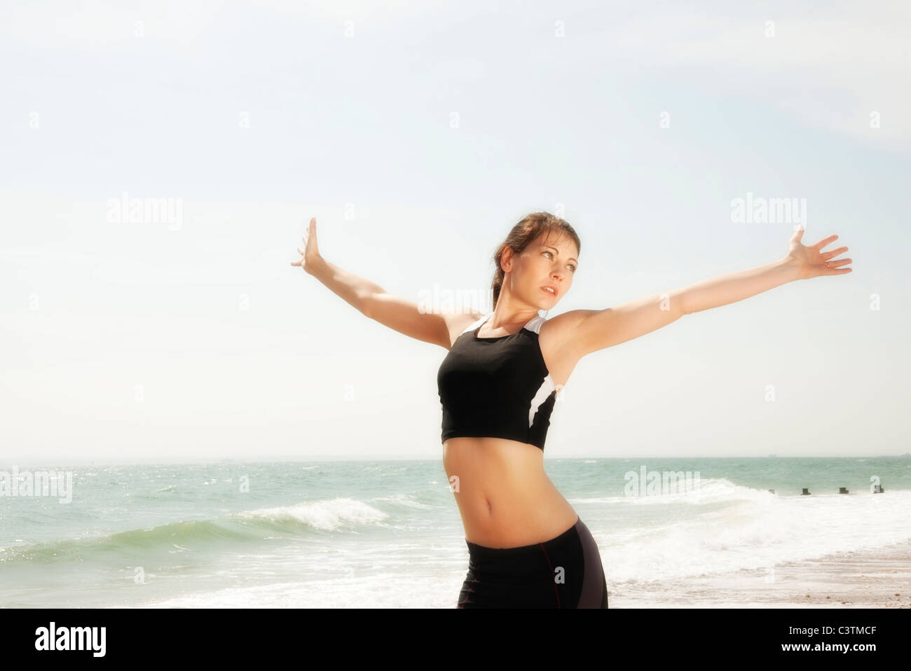 woman stretching arms out feeling the breeze after having a run on the ...
