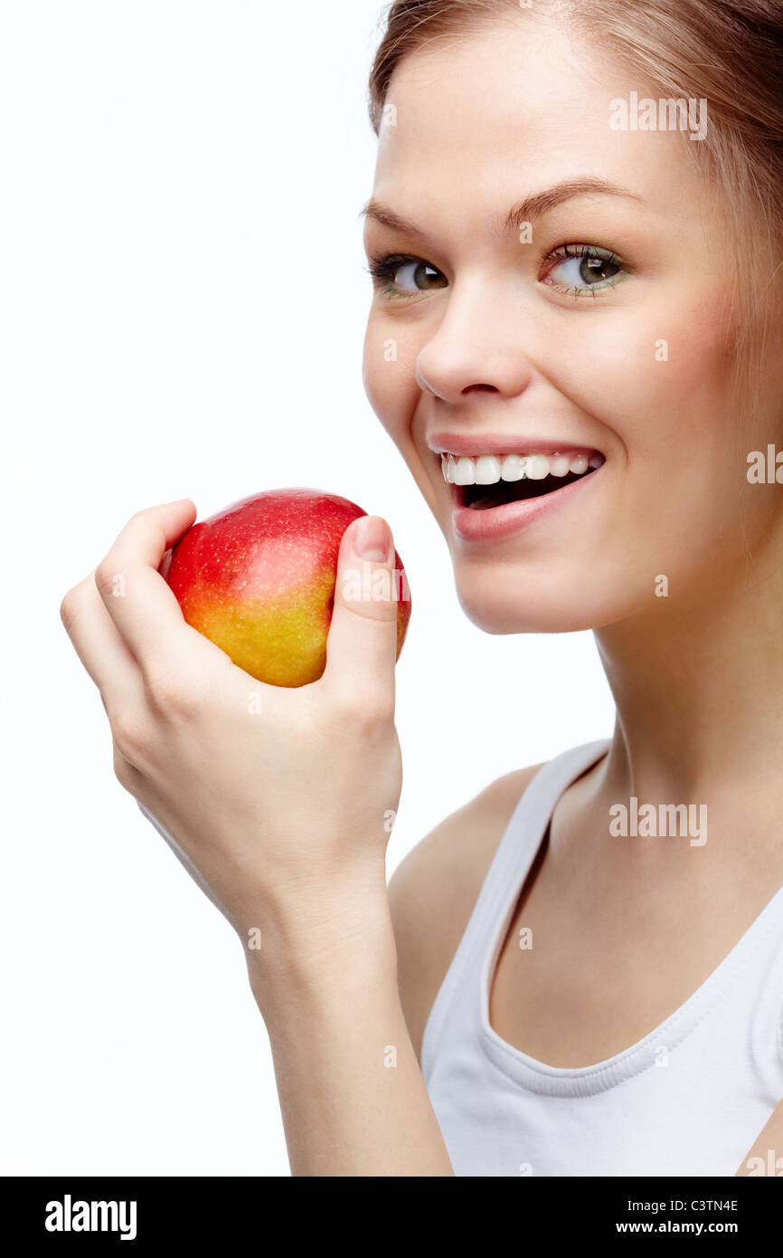 Portrait of a young girl biting an apple Stock Photo - Alamy