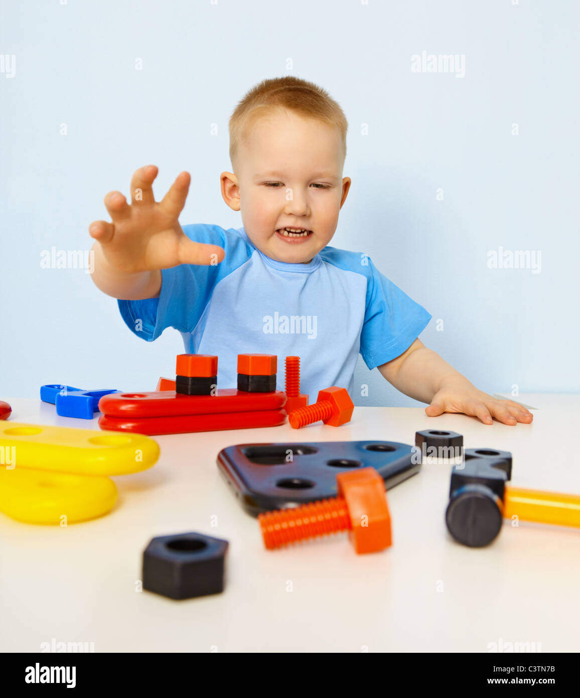 Funny kid playing with colored plastic parts Stock Photo - Alamy