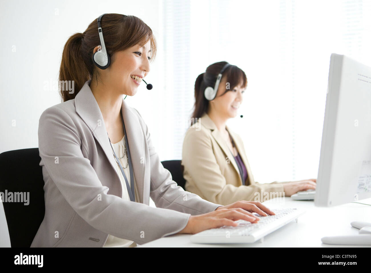 Two customer service representatives work hi-res stock photography and ...