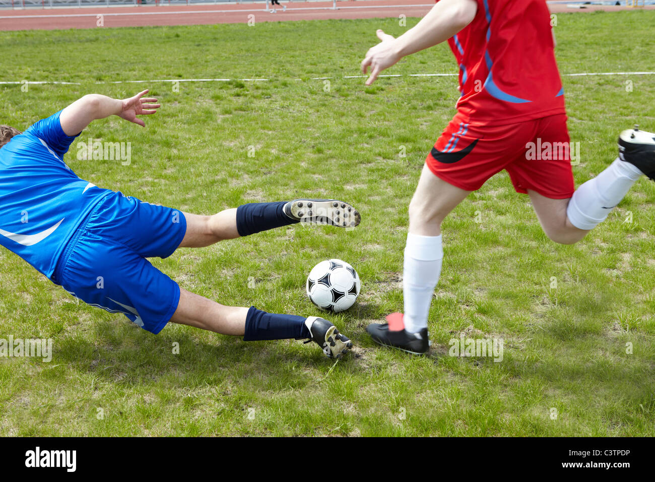 Two footballers chasing ball on grass-field during game Stock Photo - Alamy