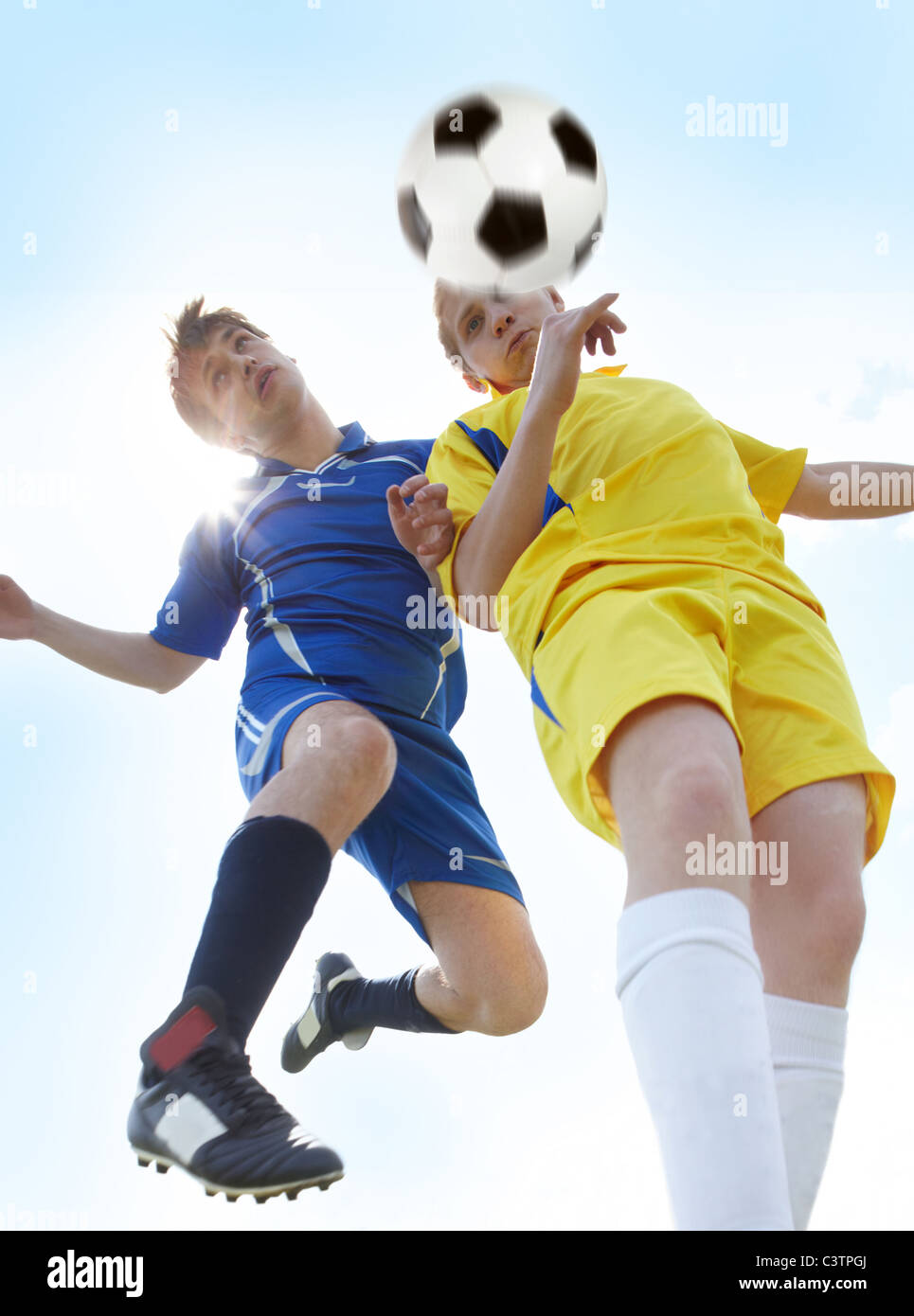 Two footballers jumping on grass-field during game Stock Photo - Alamy