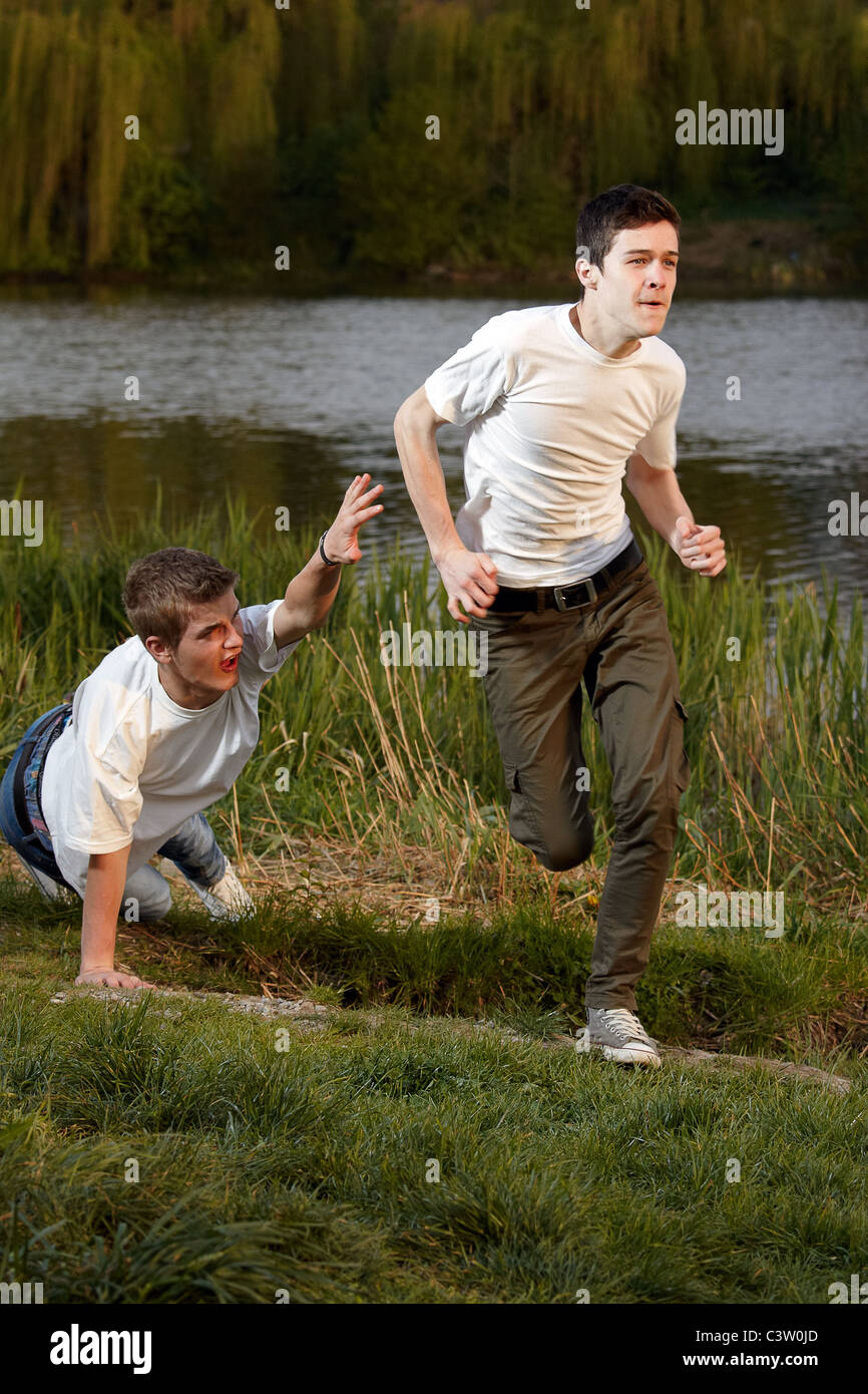 A young man fell in running next to his friend Stock Photo - Alamy