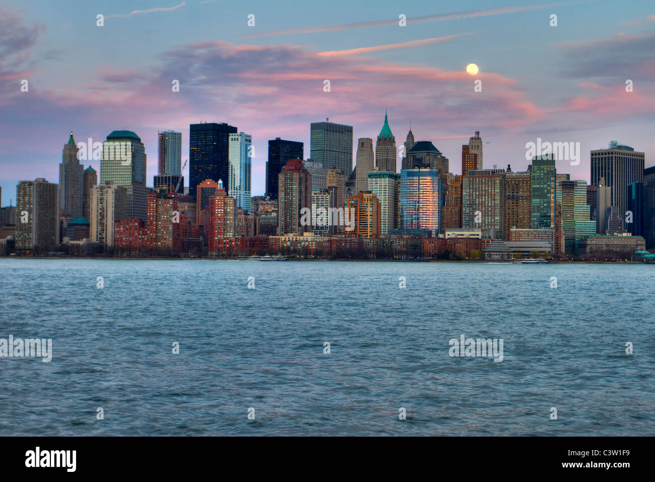 Full moon rising over lower Manhattan at sunset seen from across the ...