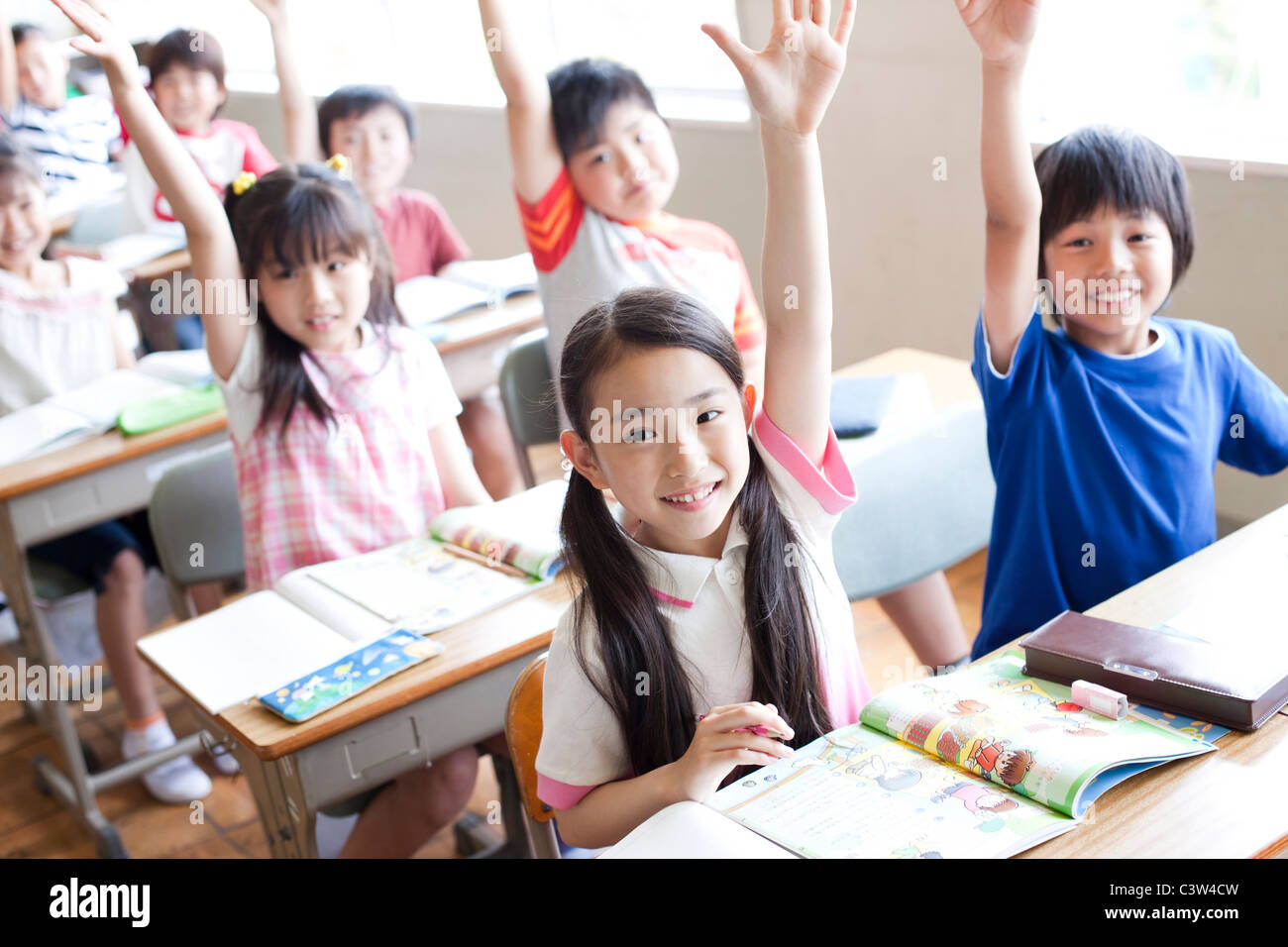 Schoolchildren Raising Hands in Classroom Stock Photo - Alamy Schoolchildren Raising Hands in Classroom Stock Photo - Alamy