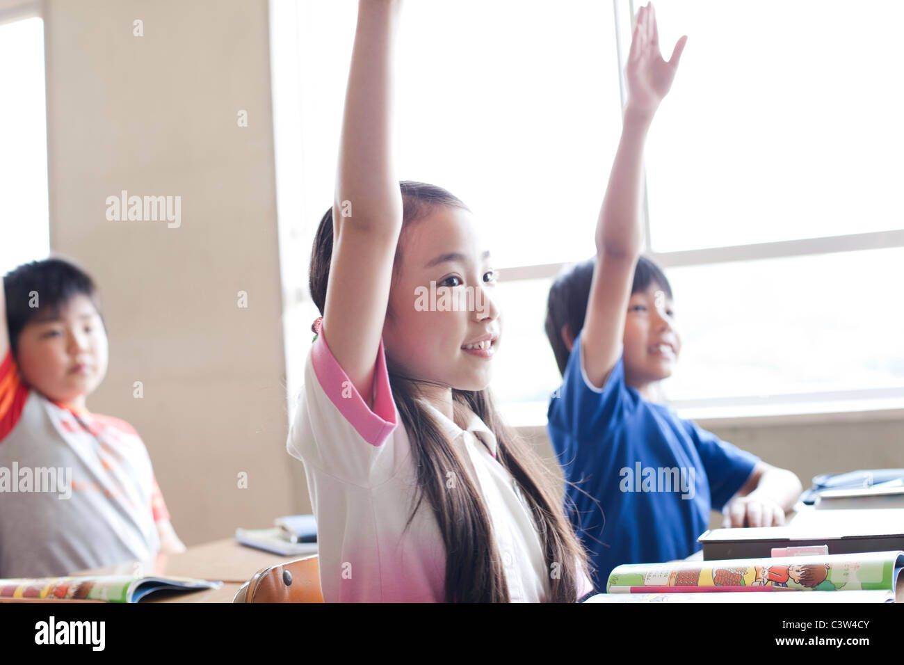 Schoolchildren Raising Hands in Classroom Stock Photo - Alamy Schoolchildren Raising Hands in Classroom Stock Photo - Alamy