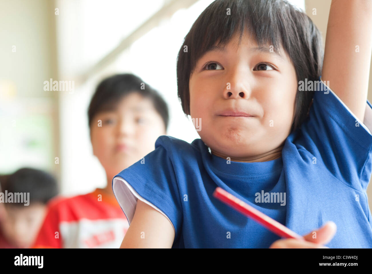 Eager boy raising hand in hi-res stock photography and images - Alamy