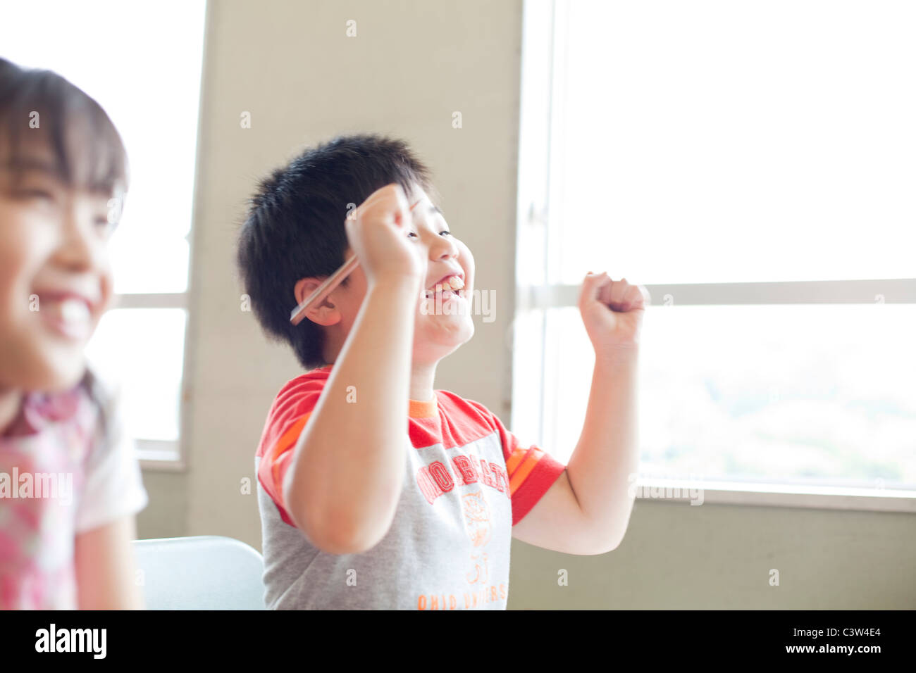 Boy Celebrating Success in Classroom Stock Photo - Alamy