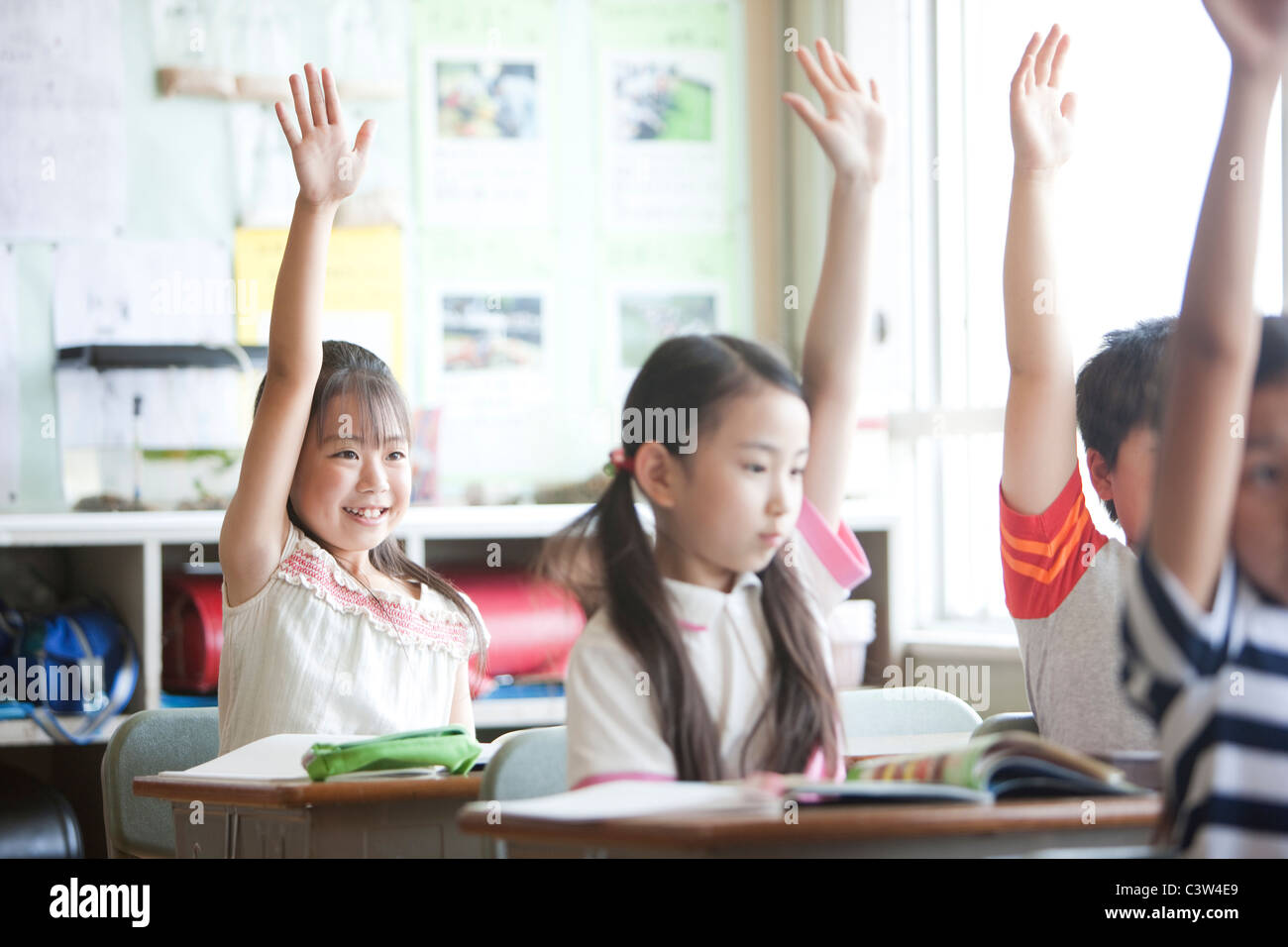 Classroom raising hands hi-res stock photography and images - Alamy