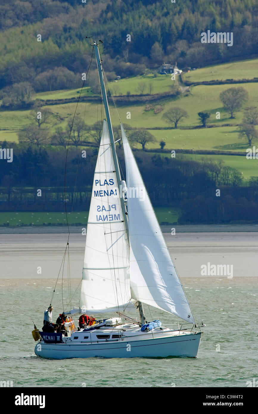 A yacht from the Plas Menai Sailing centre on the Menai Straits in ...