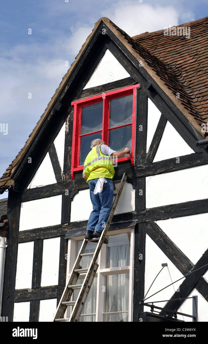 A painter up a ladder Stock Photo - Alamy