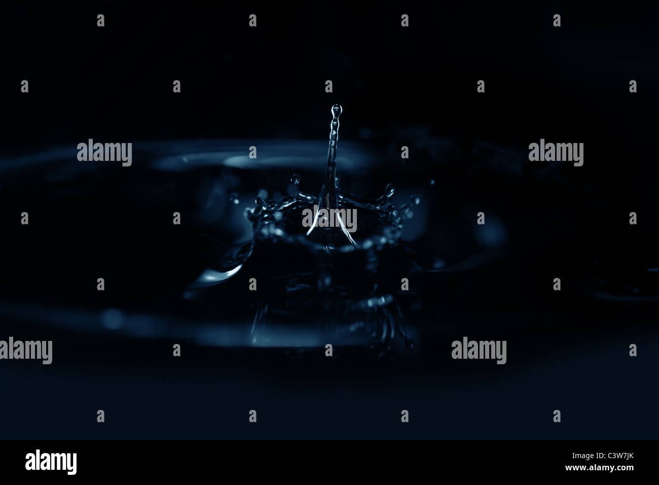 Extremely macro photo of the liquid splashing with light reflections ...