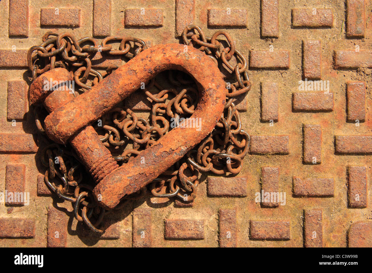 Rusty iron shackle and chain on drain-cover Stock Photo - Alamy