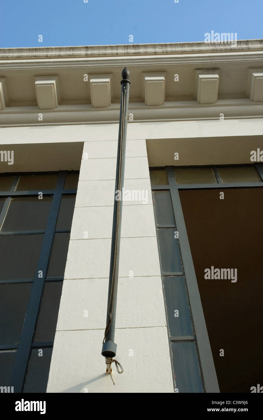 Architectural detail of an antique building with a flagpole. Blue sky ...
