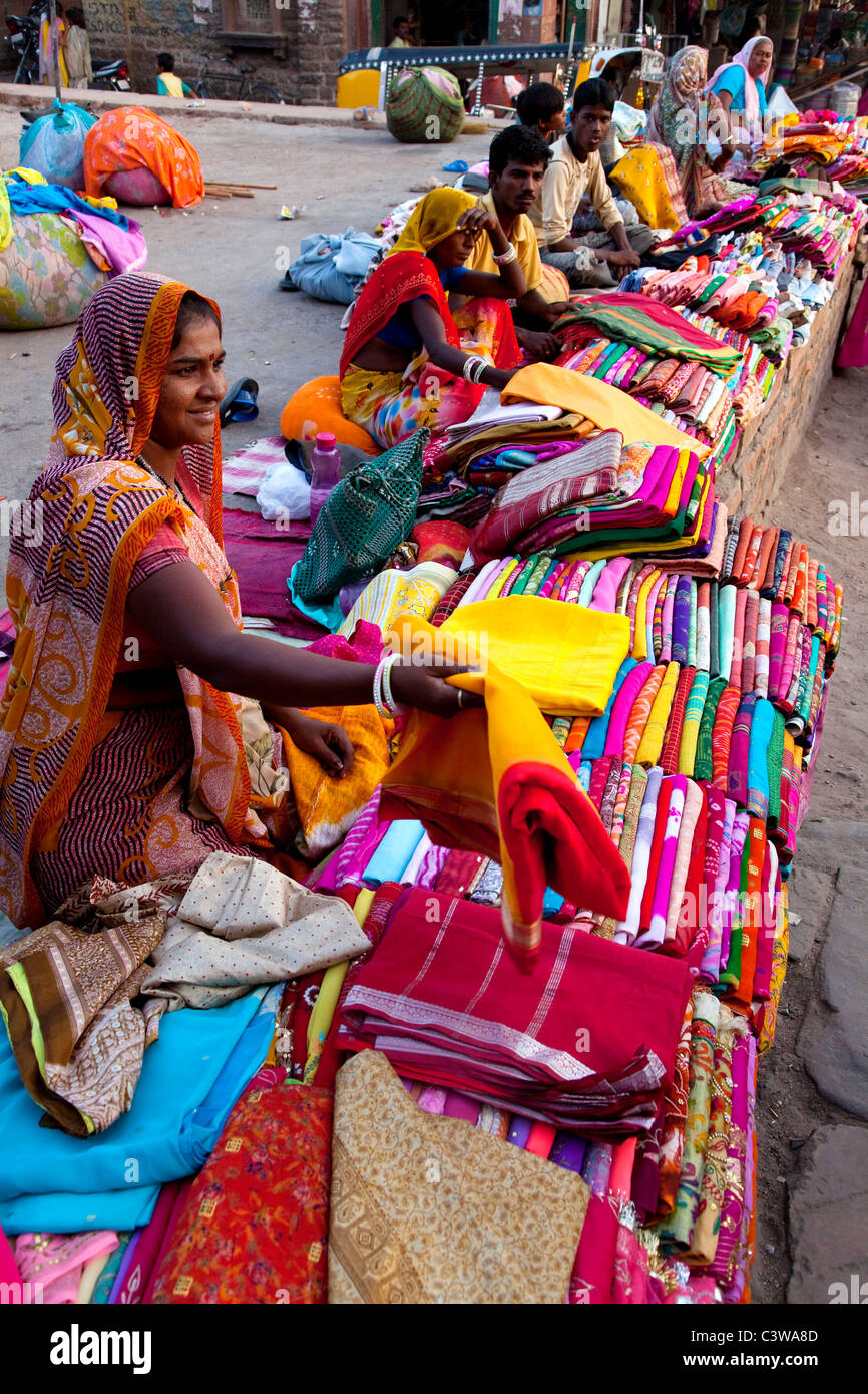Indian women and men selling clothes, sari, textiles, fabrics at city ...