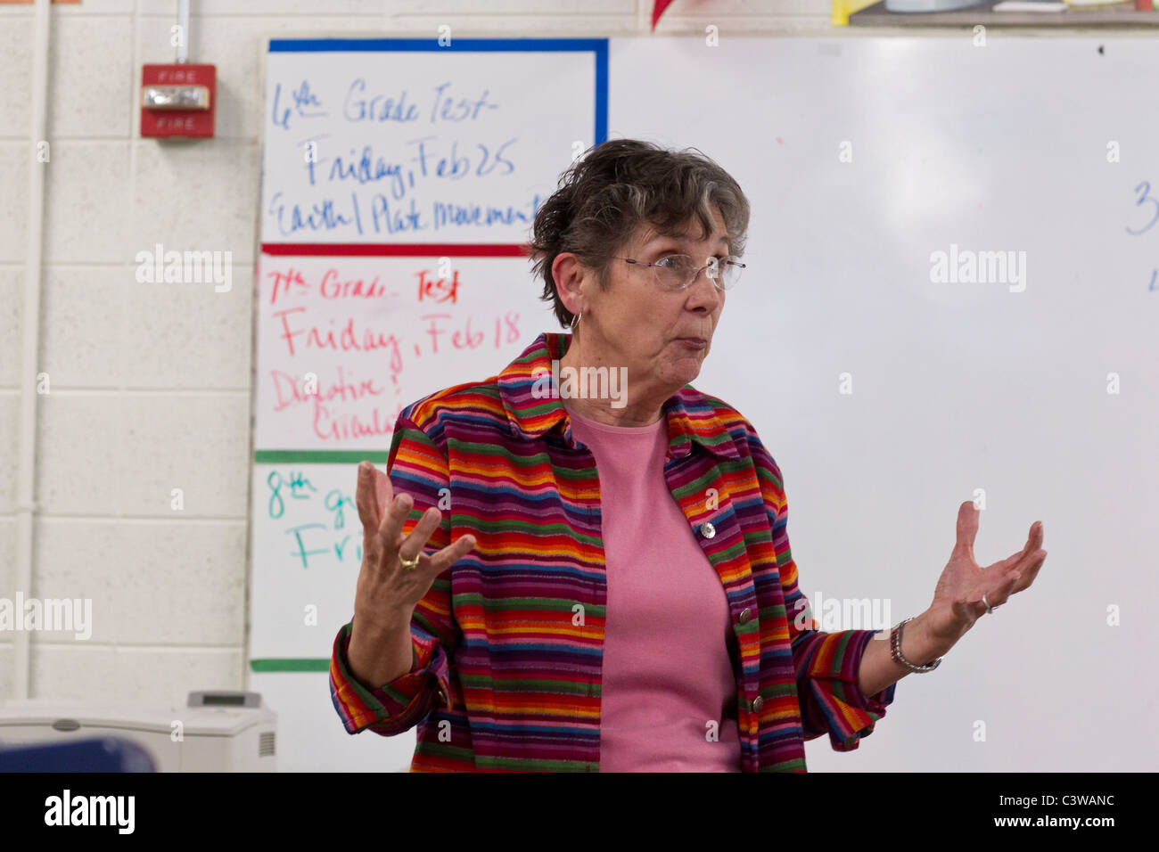 Female Anglo chemistry teacher gestures while talking to students in ...